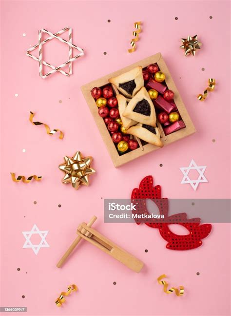 휴일 맛있는 Hamantaschen 쿠키 빨간 카니발 마스크 소음 메이커 달콤한 사탕과 핑크 배경파티 장식 개념에 대한 스톡