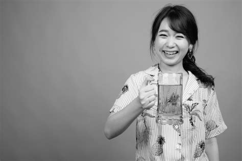 Premium Photo Portrait Of A Smiling Girl Standing Against Gray Background