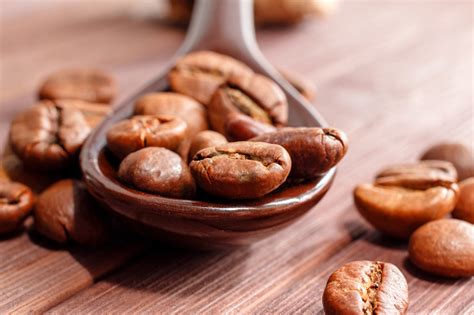 곡물 커피 확대해입니다 커피 콩 나무 질감 중 숟가락에 있습니다 커피 알갱이 나무로 되는 숟가락에 있습니다 자바 커피의 전체 곡물으로 구성입니다 갈색에 대한 스톡 사진 및