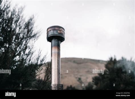 Metallic Warm Smoking Chimney In The Middle Of Nature And Trees Near