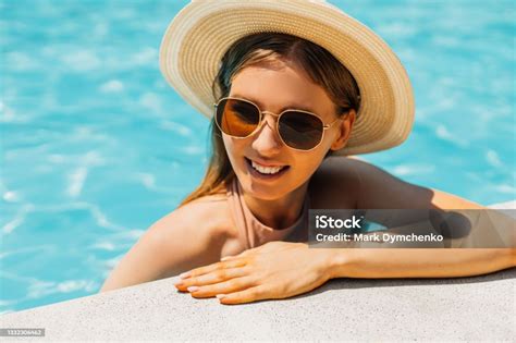 선글라스와 여름 모자를 쓴 젊은 무두질 한 여성 야외 수영장에서 수영복을 입은 여성 수영장에서 휴식을 취하는 여성 고급 호텔에 대한 스톡 사진 및 기타 이미지 Istock