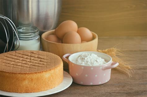 흰색 접시에 만든 스폰지 케이크입니다 소프트 하 고 라이트 맛 있는 스폰지 케이크 재료 계란 밀가루 우유 나무 테이블에 베이커리
