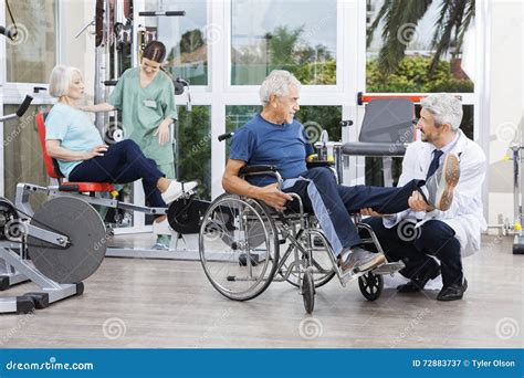 Physiotherapists Guiding Patients To Exercise At Rehab Fitness C Stock