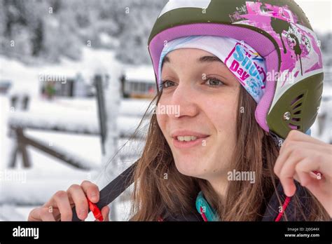 Woman With Brown Hair Smiling While Adjusting Her Ski Helmet Getting
