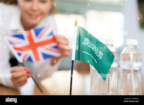 Businesswoman Arranging The Flags Of Saudi Arabia And Great Britain For