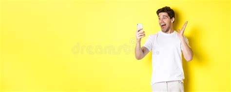 Surprised And Happy Man Looking At Mobile Phone Screen Reading