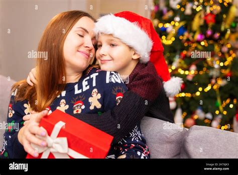 Mother And Son Hugging And Giving Ts At Christmas At Home In The