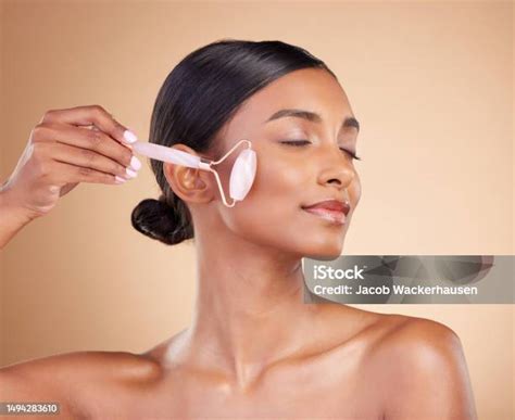 여성 롤러 및 얼굴은 스킨케어 뷰티 화장품 또는 피부과 스튜디오 배경에 대한 노화 방지를 위한 것입니다 얼굴 치료 자연 건강 및 웰빙을 위한 행복한 여성 모델 롤링 스킨