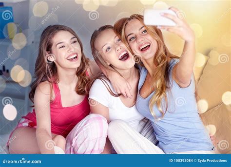 Предназначенные для подростков девушки при Smartphone принимая Selfie