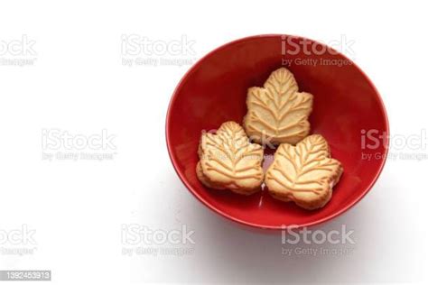 캐나다 나무의 꿀이나 메이플 시럽으로 만든 바닐라 크림으로 가득 찬 맛있는 쿠키 심장 모양의 빨간 그릇에 캐나다의 전통적인