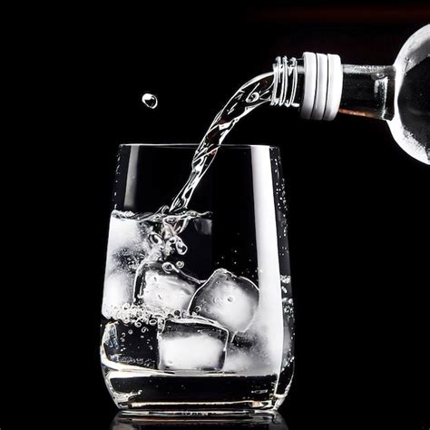 Premium Ai Image Pouring Gin Tonic Drink Into A Glass On Black Background
