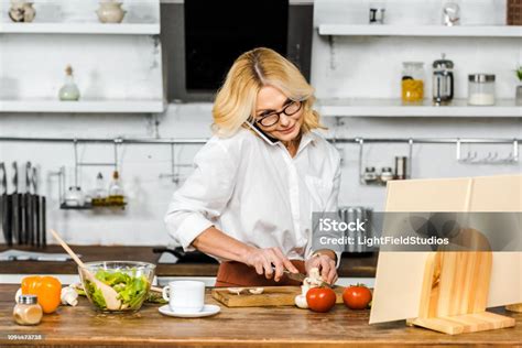 매력적인 여 인 스마트폰 여 야채를 절단 하 고 부엌에서 요리 책을 보고 건강한 생활방식에 대한 스톡 사진 및 기타 이미지 건강한 생활방식 건강한 식생활 날것