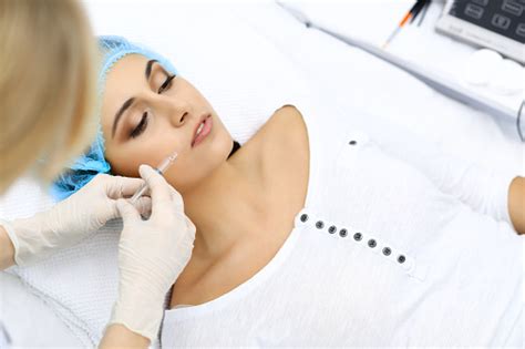 전문 미용사 얼굴 입술에에서 주입을 만들기입니다 젊은 여자는 얼굴 윤곽 또는 확대에 대 한 필러를 주사기를 가져옵니다 얼굴 노화 회복 및 수 분 절차입니다 미적 화장품 건강