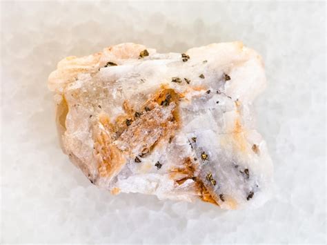 Oro nativo en piedra de cuarzo en bruto sobre mármol blanco Foto Premium