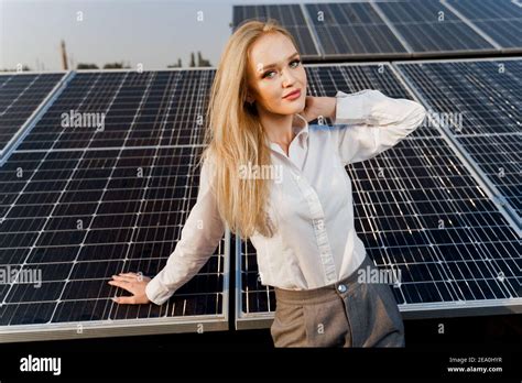 Blonde Model With Solar Panels Stands In Row On The Ground Girl