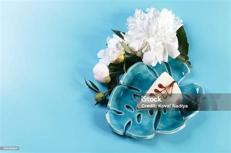 블루 톤에 그림 같은 정 백색 Pions 파란색 배경 복사 공간 평면도 세트에 의해 포위 하는 치즈 케이크의 조각으로 장식 접시