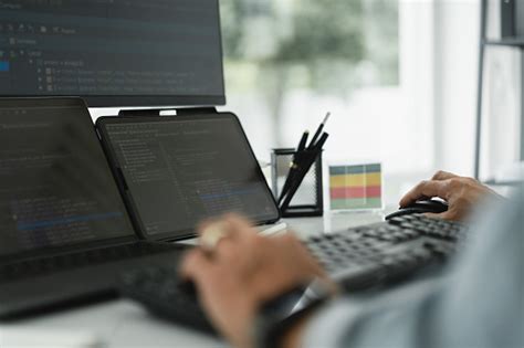 Developer Programmer Checking Code On Multiple Monitor While