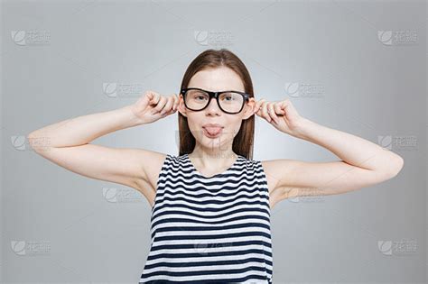 戴眼镜的少女露出舌头，做鬼脸