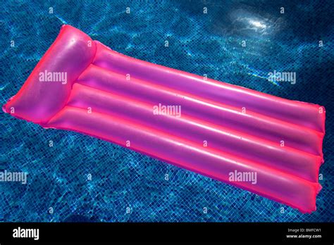 Pink Lilo Airbed In Swimming Pool In Sunshine Summer Stock