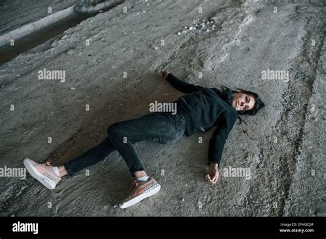 Corpse Of Female Victim Of Crime Lying Down On The Ground Of Abandoned