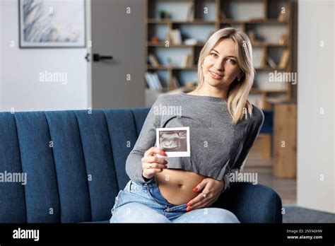 Photo Of A Pregnant Woman At Home Sitting On Couch Near Beautiful