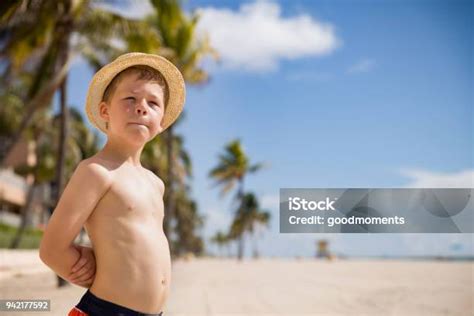 모래 해변에 서 서 거리에 보고 웃 고 밀 짚 모자에 귀여운 꼬마 소년의 초상화 야외 여름 시간입니다 행복 한 아이 바다에 의해입니다 바다 해변에서 휴가에 학교 소년입니다