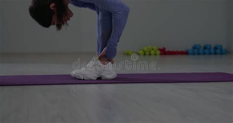 Athletic Girl Performs Forward Bends For Stretching In A Bright Gym