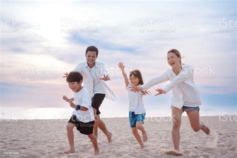 행복한 아시아 가족은 바다 해변에서 여름 방학에 해변에서 즐거운 시간을 보내는 아버지 어머니 아들 딸로 구성된 바다 해변을 즐깁니다 휴가 시간 라이프 스타일 개념을 가진