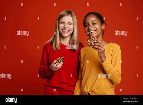 Multiracial Two Girls Laughing While Posing With Cookies Isolated Over