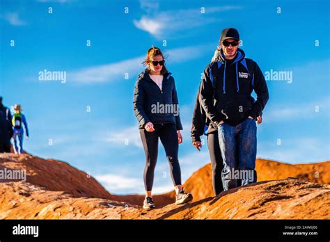 Tourists Climb Over The Steep Undulating Terrain On Top Of Uluru