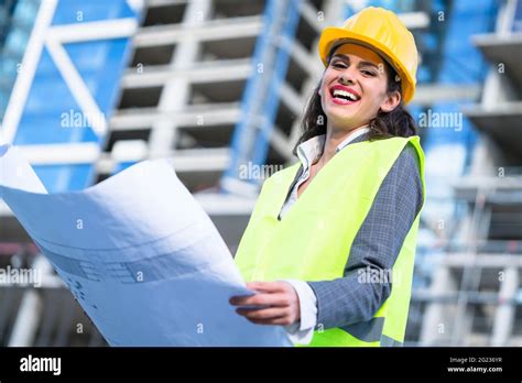 Female Architect Studying Drafts While Visiting Large Construction Site Stock Photo Alamy
