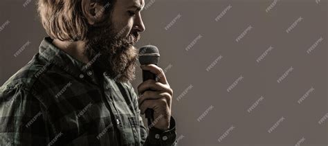 Premium Photo Bearded Man In Karaoke Sings A Song Into A Microphone