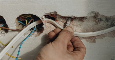 사람이 방의 전등 스위치를 고치고 있습니다 사진 Unsplash의 혁신 이미지