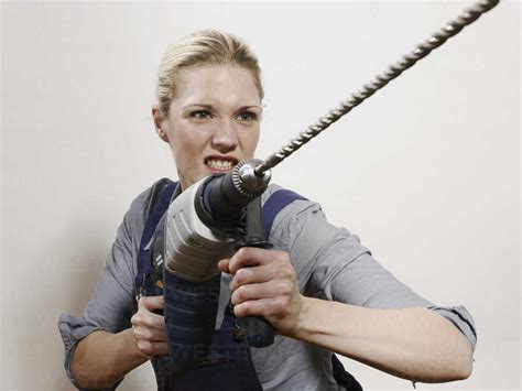 A Woman Holding A Drill Stock Photo