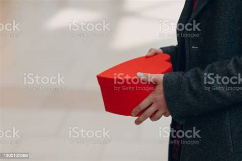 남자는 발렌타인 데이에 그의 여자 친구에게 하트 모양의 상자를 제공합니다 쇼핑몰에서 젊은 부부 18 19세에 대한 스톡 사진 및