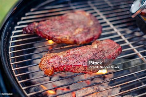 맛있는 스테이크와 립아이 바베큐 스톡 사진 소스는 고기 위에 퍼집니다 그릴 아래에서 불이 나고 있습니다 0명에 대한 스톡 사진