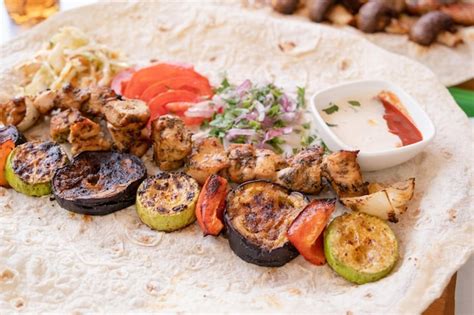 Premium Photo Grilled Kebab With Pita Bread And Vegetables On Tray In