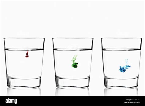 Red Green And Blue Food Color Diffusing Into Three Glasses Of Water