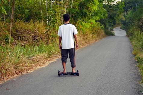 Premium Photo Young Man Riding Hoverboard On Black Asphalt Road