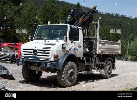 A White Mercedes Benz Unimog G5000 Off Road Truck With A Crane Parked