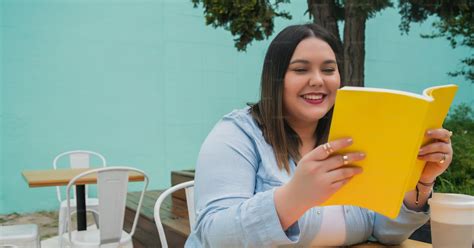 커피숍에서 야외에 앉아 자유 시간을 즐기고 책을 읽는 젊은 플러스 사이즈 여성의 초상화 사진 Unsplash의 책 이미지