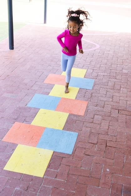 Premium Photo In School Young Biracial Girl Is Playing Hopscotch