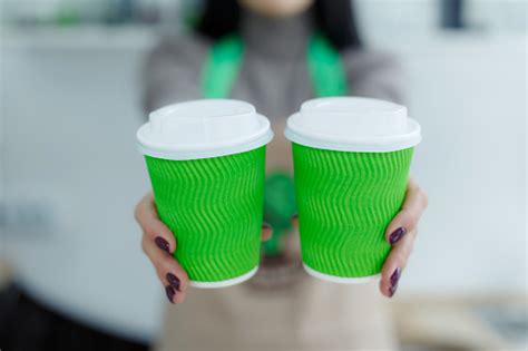 앞치마에 있는 바리 스타가 녹색 테이크아웃 종이 컵에 뜨거운 커피를 손에 들고 있습니다 카페 샵에서 커피를 맛 보세요 고객에 대한 스톡 사진 및 기타 이미지 Istock