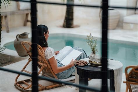 Una Mujer Sentada En Una Silla Leyendo Un Libro Foto Imagen De