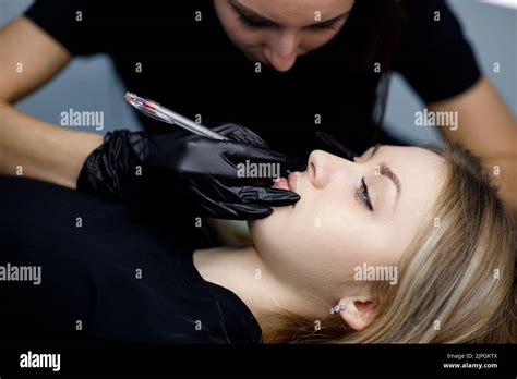 Cosmetologist Applying Drawing Contour On Lip Before Making Lips