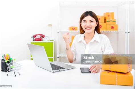 우편 소포와 나무 바닥에 집에서 노트북 컴퓨터를 작동 하는 여자 온라인 아이디어 개념을 판매 하는 여자 온라인 판매 중소 기업 소유자 노트북을 사용 하 여 작업 시작 가정