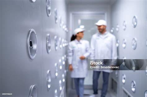 생산 라인에 들어가기 전에 먼지와 입자를 제거하는 산업용 에어 블로잉 터널에 서 있는 공장 작업자 음식과 음료 산업에 대한 스톡