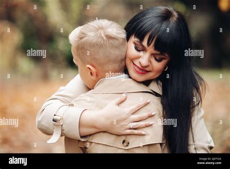Mom And Son Are On Good Terms Walking In The Park Chatting Stylish