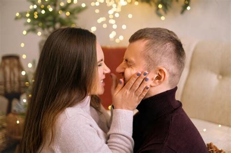 Premium Photo Woman Pinches Husbands Cheeks Making Funny Face
