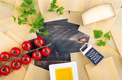 라자 냐 요리에 대 한 성분입니다 라자 냐 파 르 메 산 치즈 체리 토마토 올리브유와 허브 나무 소박한 배경에 이탈리아 요리